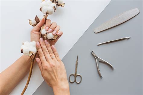 세련 된 트렌디 한 여성 핑크 매니큐어입니다 아름다운 젊은 여성은 꽃회색 배경에 손을 최소한의 창조적 인 개념 플랫 레이 상단