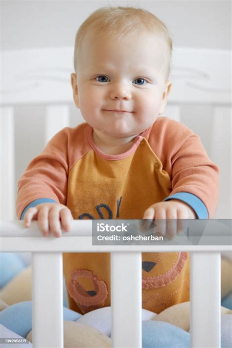 재미있는 아기 얼굴 첫 번째 우유 또는 임시 치아를 가진 작은 귀여운 신생아 소년 어린이실에서 침대에서 웃고 있는 사랑스러운