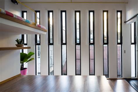 Narrow windows allow daylight into House by Khuôn Studio