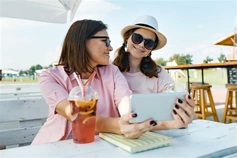 행복 한 엄마와 사춘기 딸 얘기 하 고 웃 고입니다 스마트폰에 걸릴 Selfie 뜨거운 여름 날에 차가운 음료를 즐기는 여름 야외 카페에서 자녀와 부모 14 15 살에 대한