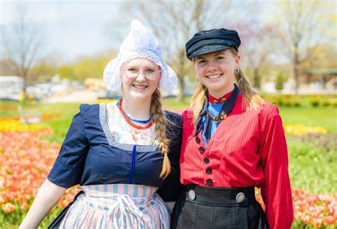 Smiling Teen Girls In Dutch Clothes At Tulip Field Editorial