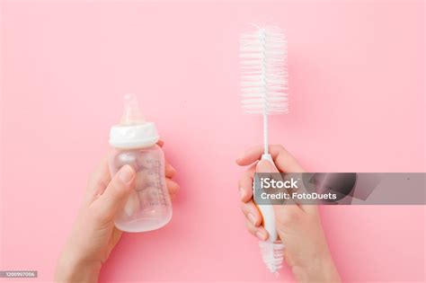 파스텔 핑크 테이블 배경에 아기 우유 병과 흰색 브러시를 들고 어머니 손 세탁 준비 근접 촬영 시점 샷 하향하 보기 병에 대한 스톡 사진 및 기타 이미지 Istock