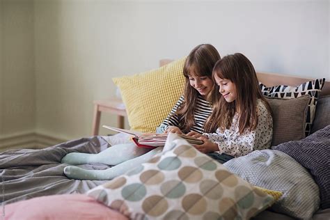 Sisters Lying On A Bed And Reading By Stocksy Contributor Lumina Stocksy