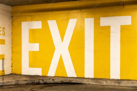 Yellow Exit Sign Painted Onto Wall Of Underground Car Parking Facility Stock Photo Adobe Stock
