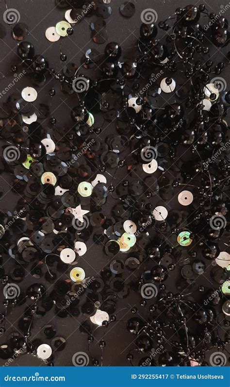 Background Of Black And Light Sequins And A String Of Black Beads On A Black Background Stock