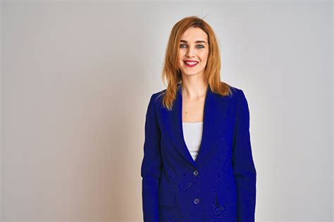 빨간 머리 백인 비즈니스 여자 얼굴에 행복하고 시원한 미소와 고립 된 배경 위에 양복을 입고 운이 좋은 사람 경영자에 대한 스톡