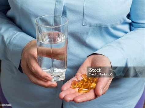 오메가 3 생선 기름 건강의 노란 약 캡슐 보충 반면에 물으로 여자 팜 손과 유리에서 약 개념에 대한 스톡 사진 및 기타 이미지 Istock