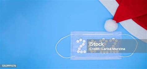 의료 용 얼굴 마스크와 파란색 배경에 산타 모자에 숫자 2022의 형태로 흰색 의료 알약 크리스마스 의학 은 평평하게 0명에 대한 스톡 사진 및 기타 이미지 Istock