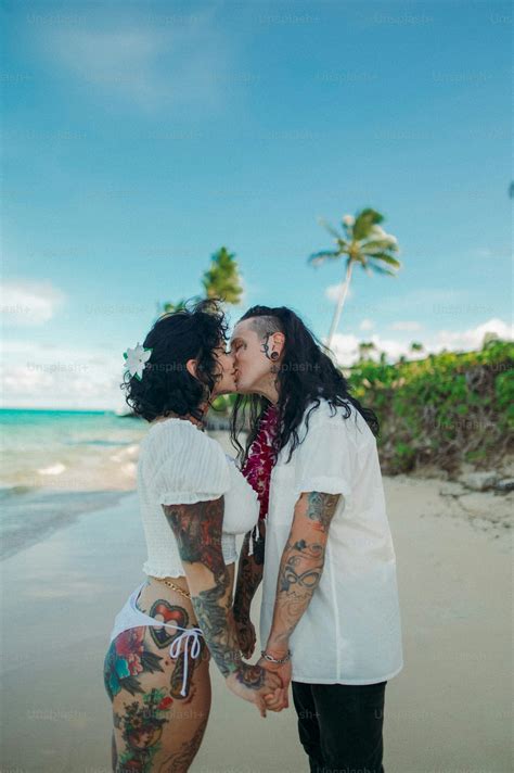 A Man And A Woman Kissing On The Beach Photo Tattooed Image On Unsplash