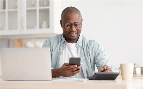 Savings And Finances Concept Mature Black Man Using Calculator Phone And Laptop Computer Stock