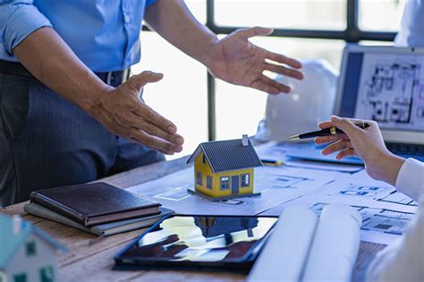 사무실 책상에서 청사진을 논의하고 검토하는 동료를 위한 엔지니어링 팀 회의 작업장에서 건설 및 개조 건물 프로젝트를 계획하는 엔지니어 및 작업자 Crash Site에 대한