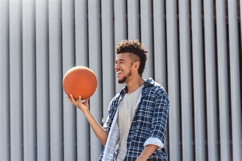 스포츠 취미 아프리카계 미국인 남자 서 고립 에 도시 거리 와 공 올라 웃음 쾌활한 측면 보기 갈색 머리에 대한 스톡 사진 및 기타 이미지 Istock