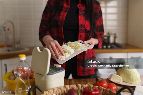 집에서 저녁을 요리하고 퇴비 통에서 유기농 음식물 쓰레기를 재활용하는 여자 집에서 보카시 용기에 남은 음식을 퇴비화하는 여성