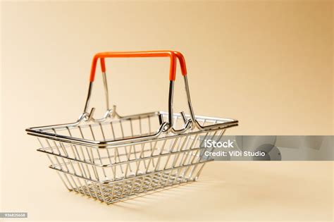 제기 처리와 베이지색 배경에 절연 주황색 플라스틱 요소 슈퍼마켓에서 쇼핑을 위한 금속 식료품 바구니 닫습니다 쇼핑의 개념입니다 광고에 대 한 공간을 복사 Publicity