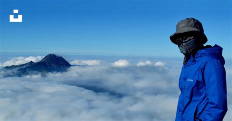 파란색 재킷을 입고 검은 모자를 쓴 남자가 낮에 눈 덮인 땅에 서 있다 사진 Unsplash의 무료 모험 이미지