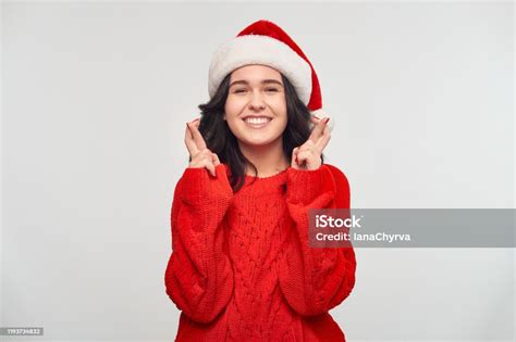 빨간 스웨터와 산타 클로스 모자를 들고 손가락을 들고 소녀는 최고의 선물에 대한 꿈을 교차 겨울에 대한 스톡 사진 및 기타