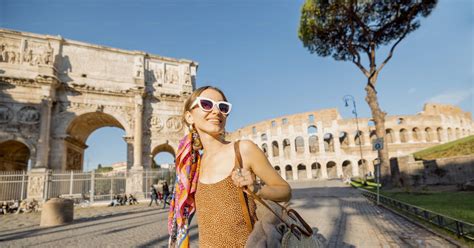 로마의 콜로세움과 콘스탄티누스 아치 앞에 있는 쾌활한 여성의 초상화 여름 드레스를 입고 머리에 화려한 숄을 두른 백인 여성 이탈리아 스타일과 여행의 개념 사진