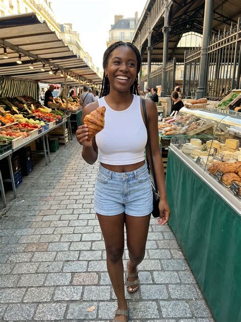 Woman Enjoying Street Food At A Parisian Market Wearing Denim Shorts