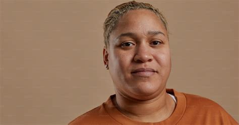 스튜디오에서 중립적인 배경에 대해 포즈를 취하는 동안 카메라를 보고 있는 짧은 머리 혼혈 여성의 초상화를 클로즈업하고 공간을 복사한다 사진 Unsplash의 아프리카계