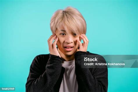 겁에 질린 아시아 인은 파란 배경에 고립 되어 충격을 받았다 나쁜 소식 때문에 한국인 남자를 스트레스와 우울하게 했다 손에 대한 스톡 사진 및 기타 이미지 Istock