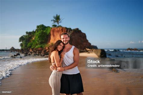 해질녘 열대 해변에서 포옹하는 미소 짓는 커플 행복한 남자 여자가 여름 방학 바다를 즐긴다 로맨틱한 휴양지 바다를 통한 레저