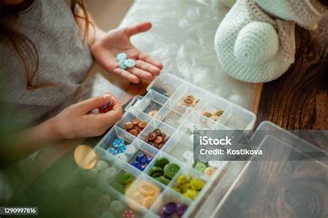 작은 귀여운 소녀는 뜨개질 눈사람을위한 버튼을 선택합니다 새해 장식이 테이블 위에 있습니다 크리스마스 컨셉 준비 단추 봉제 제품에 대한 스톡 사진 및 기타 이미지 Istock