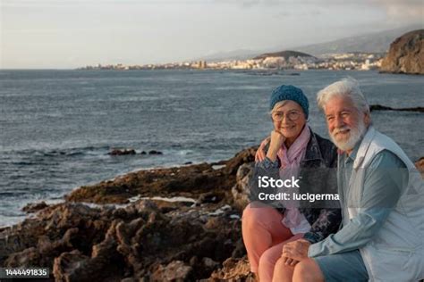 바다의 바위에 앉아 일몰 빛에 여행과 자연을 즐기는 아름다운 노부부 백인 은퇴자 부부를위한 편안한 생활 방식 2명에 대한 스톡 사진 및 기타 이미지 Istock