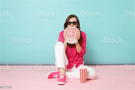 전체 길이 세로 재미 여자 장미 셔츠에서 흰색 바지 밝은 핑크 블루 파스텔 벽 배경 스튜디오에 고립 된 보고 영화 필름을 바닥에 앉아 패션 라이프 스타일 개념입니다 복사