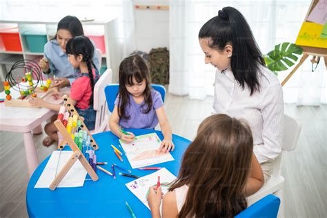 학교에서 아이들에게 예술을 가르치는 백인 아름다운 젊은 여성 교사 매력적인 강사 마스터 여성은 교실에서 학생 유치원 유치원과 함께 그림과 그림을 설명하고 교육합니다 사진
