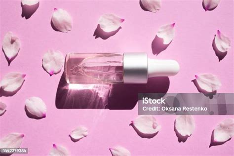 에센스와 천연 체리 꽃잎이 든 스포이드 항아리는 분홍색 배경에 그림자를 드리 웁니다 평면도 0명에 대한 스톡 사진 및 기타 이미지 Istock