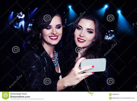 Due Ragazze Che Fanno Selfie Sul Fondo Del Partito Di Musica Fotografia