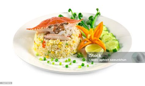 흰 배경에 고립 된 태국 사이드 뷰에서 중국과 태국 음식 융합 스타일의 인기있는 메뉴를 조각 한 채소로 장식 된 게볶음밥 건강한