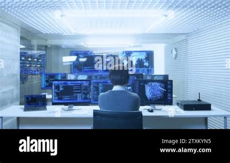 back view of the it engineer working with multiple monitors showing
