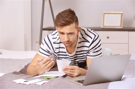 Premium Photo Confused Young Man Calculating Taxes At Home