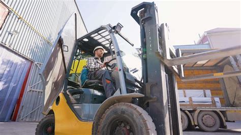 Male Forklift Driver Working On Loading And Unloading Goods In