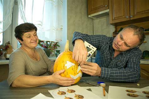 집에서 잭 오랜턴을 만들기 잭 O랜턴 테마 템플릿을 만드는 과정입니다 한 남자와 여자가 조각용 호박을 준비하고 있습니다 10월에 대한 스톡 사진 및 기타 이미지 Istock