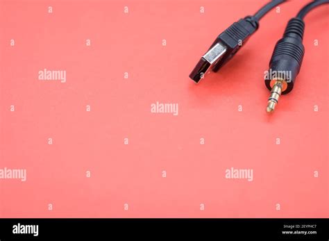 A High Angle Shot Of A USB Aux Cable Isolated On A Red Background Stock