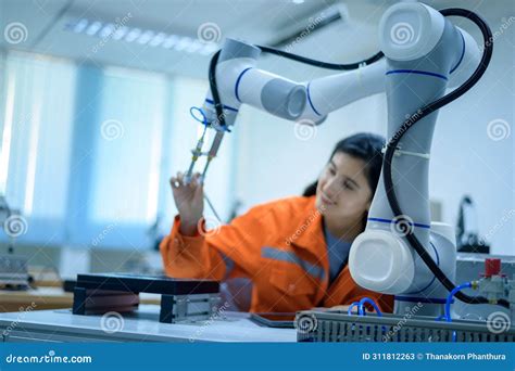 Female Robotics Engineer Working With Programming And Manipulating Robot Hand Industrial