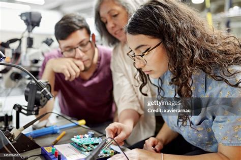 College Instructor Assisting Electrical Engineering Students High Res