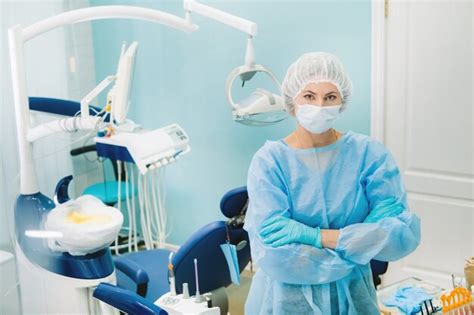 Premium Photo A Female Dentist Wearing A Medical Mask And Rubber