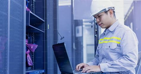 노트북을 손에 들고 작업하는 네트워크 관리자 데이터 센터의 랙 캐비닛에 코어 스위치가 있는 구성 사진 Unsplash의 구성 이미지