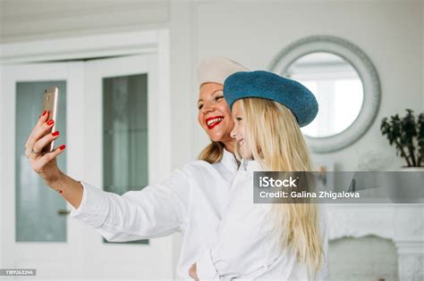 재미 행복 페어 긴 머리 엄마와 귀여운 딸이 Lliving 방에서 휴대 전화에 함께 셀카를 만드는 행복한 가족 라이프 스타일 2명에 대한 스톡 사진 및 기타 이미지 Istock