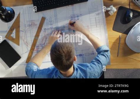 Top View Of A Technical Engineer Working On His Blueprints Drawing On