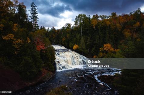 상록나무와 단풍으로 둘러싸인 바위 강바닥과 절벽을 통해 물이 흘러내리는 아래 포테이토 강 폭포의 경치 좋은 폭포 풍경의 여행