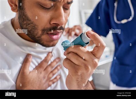 African American Nurse Helping Her Indian Patient With Asthma Inhaler