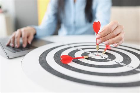 Premium Photo Female Hand Holding Dart In Dart Center At Work Table