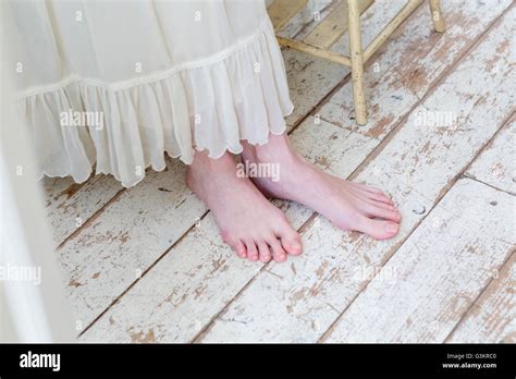 Low Section Of Woman Standing Barefoot On White Washed Floorboards