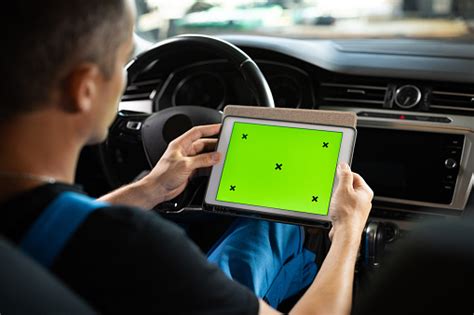 인식 할 수없는 차량 서비스 관리자 작업자 점검 및 유지 보수로 작업장에서 엔진 자동차를 수리합니다 녹색 화면 모형 크로마 키가있는 태블릿 컴퓨터에서 진단 소프트웨어를
