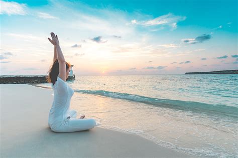 연습 요가 로터스 화이트 운동복을 입고 아시아 여자 포즈 명상 몰디브에서 해변에서 일몰 그래서 편안한 느낌 및 휴가 건강 개념에 휴식 균형에 대한 스톡 사진 및 기타 이미지