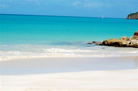 백사장 푸른 바다 하늘이 있는 카리브해 해변 해변에서 파도가 부서지고 멀리 돛단배가 있습니다 0명에 대한 스톡 사진 및 기타 이미지 Istock